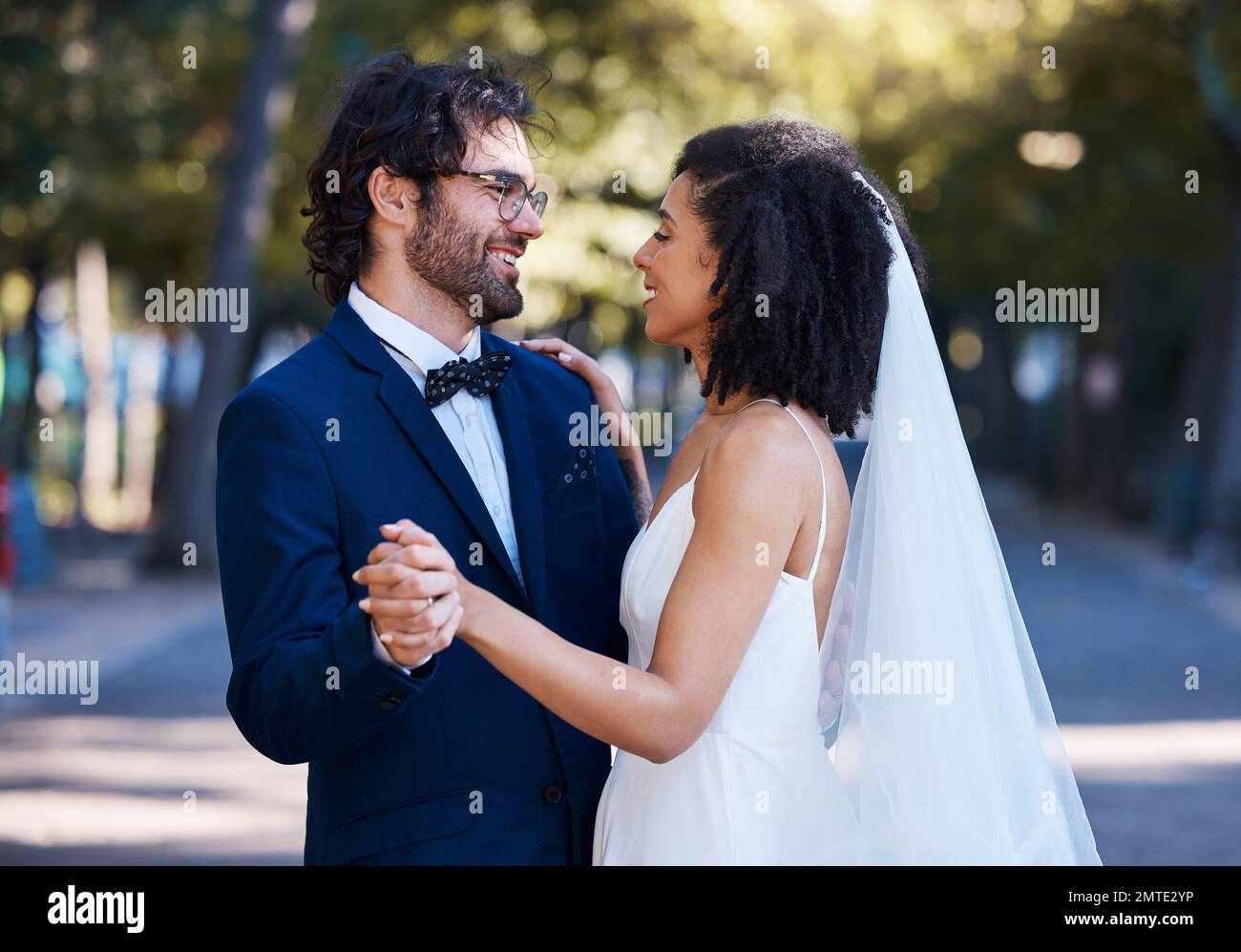 Interracial wedding, couple and dancing in street with excited smile ...
