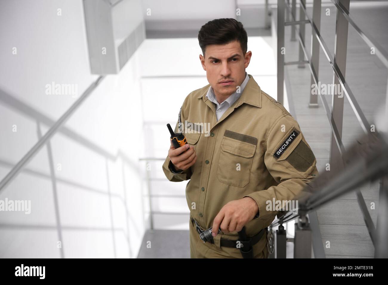 Professional security guard with portable radio set on stairs Stock ...