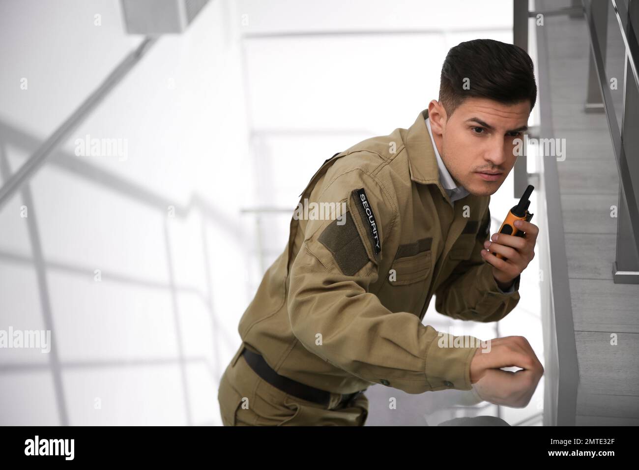 Professional security guard with portable radio set on stairs Stock ...