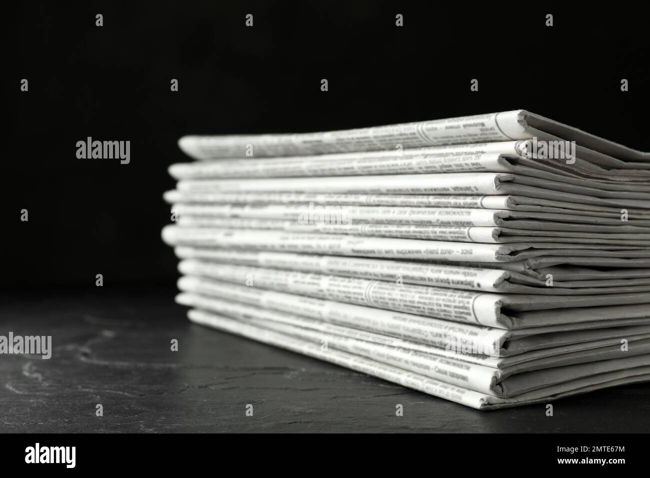 Stack of newspapers on dark stone table. Journalist's work Stock Photo ...