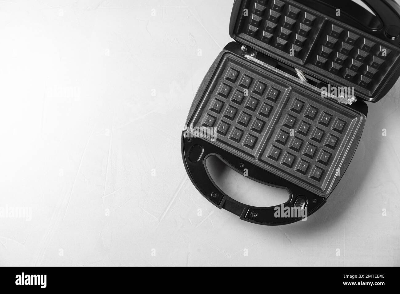 Modern waffle iron on white table, top view. Space for text Stock Photo ...