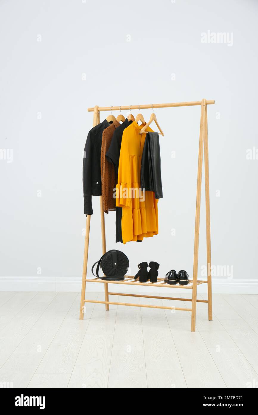 Wooden rack with stylish clothes in room Stock Photo - Alamy