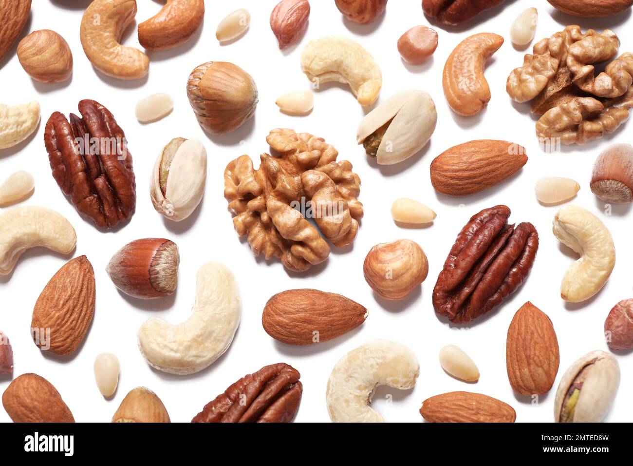 Different delicious nuts on white background, flat lay Stock Photo - Alamy