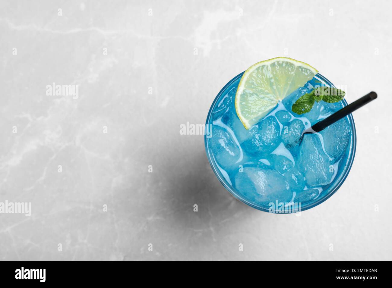 Tasty Blue Lagoon cocktail on light grey table, top view. Space for ...
