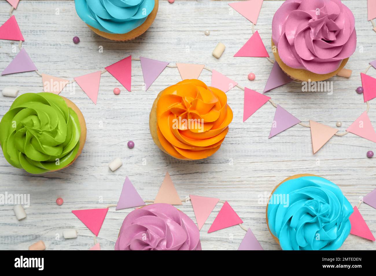 Colorful birthday cupcakes on white wooden table, flat lay Stock Photo ...