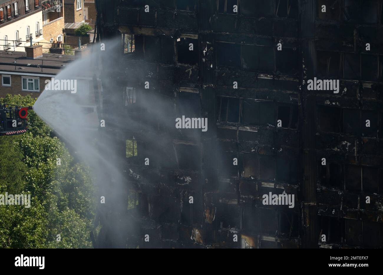 A remote controlled aerial platform pours water onto any remaining ...