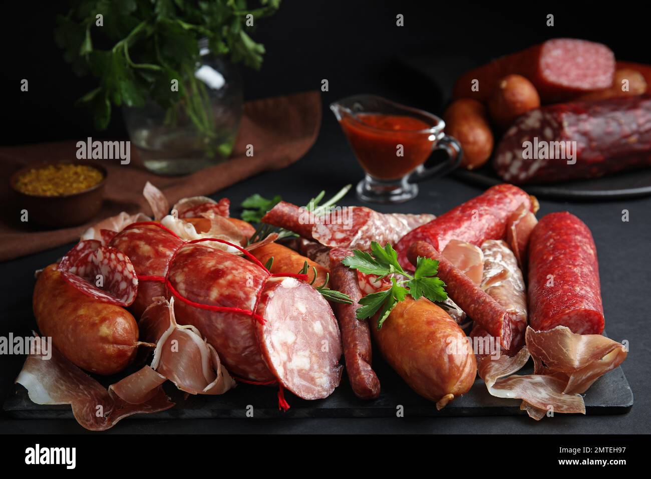 Different types of sausages served on black table Stock Photo - Alamy