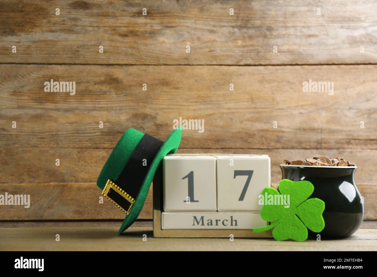 Composition with pot of gold coins and block calendar on wooden table ...