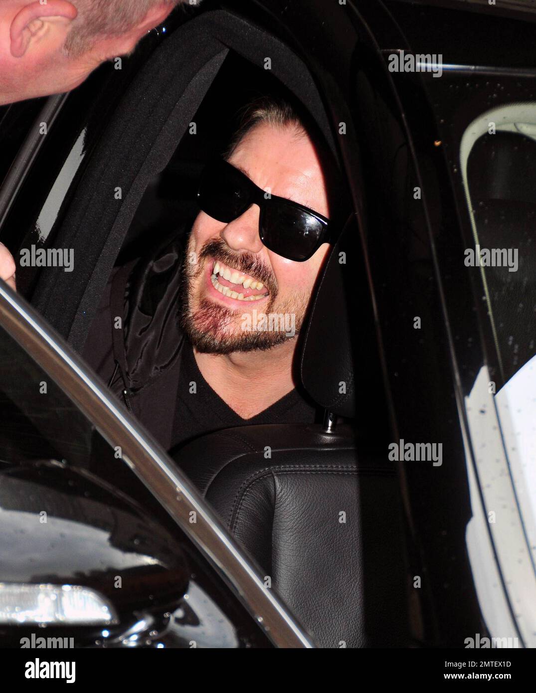 Actor and comedian Ricky Gervais is all smiles as he poses for photos ...