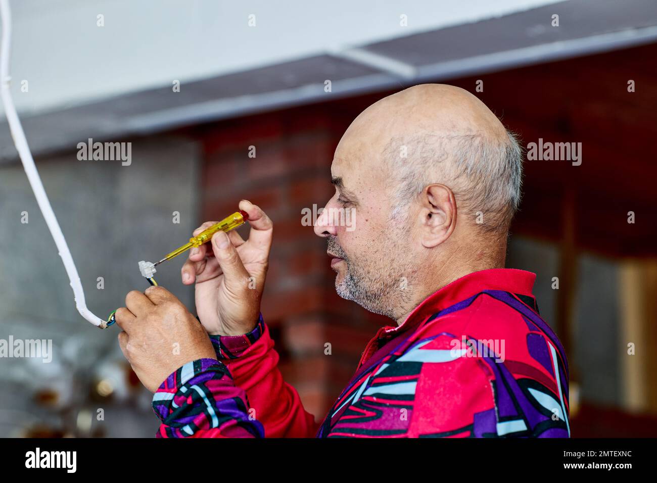 An elderly man repairs home electrical wiring Stock Photo - Alamy