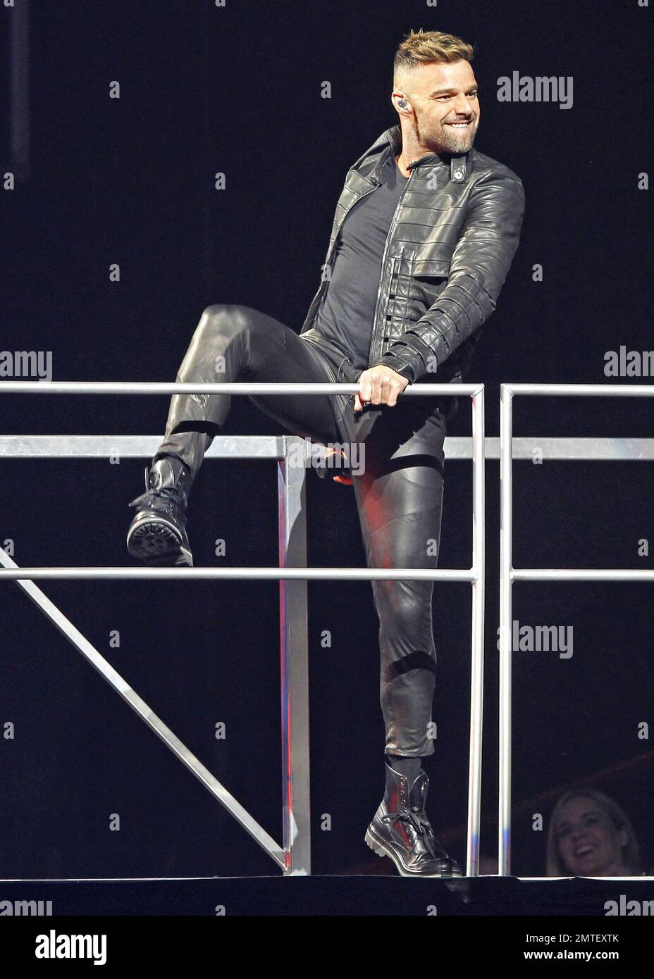 With his hair clipped short at the sides and left long at the top and ...