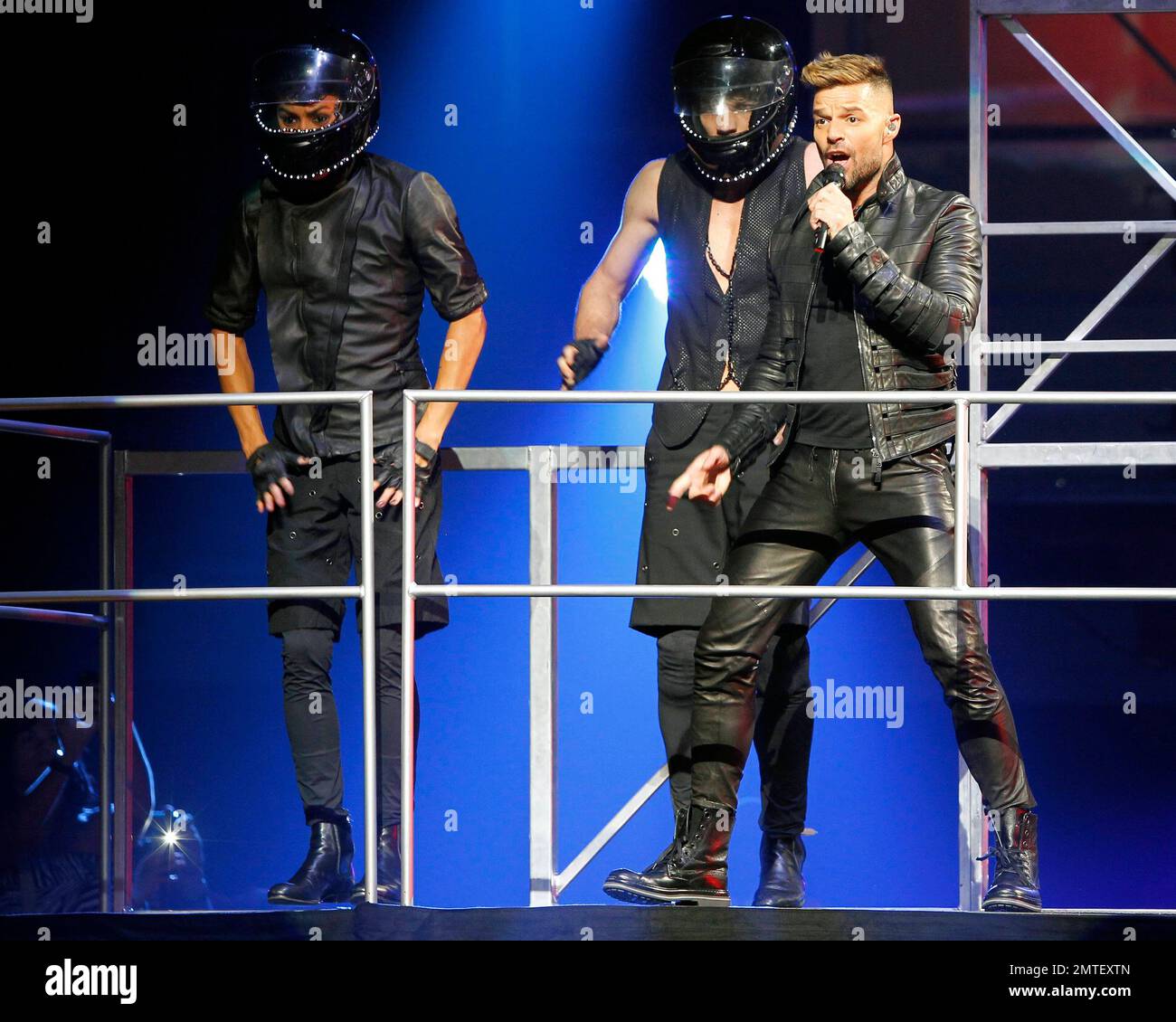 With his hair clipped short at the sides and left long at the top and ...