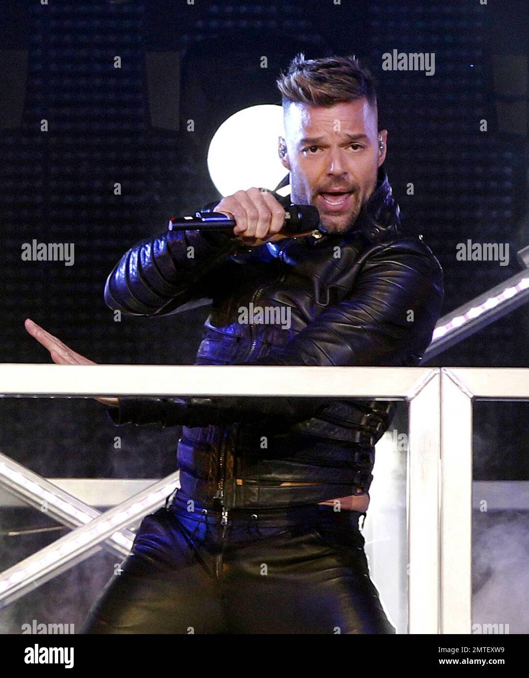 With his hair clipped short at the sides and left long at the top and ...