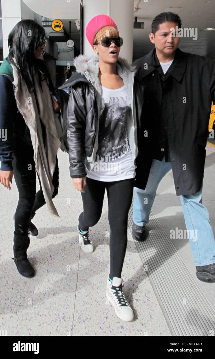 Rihanna arrives at LAX and walks to a waiting limo wearing a trendy ...