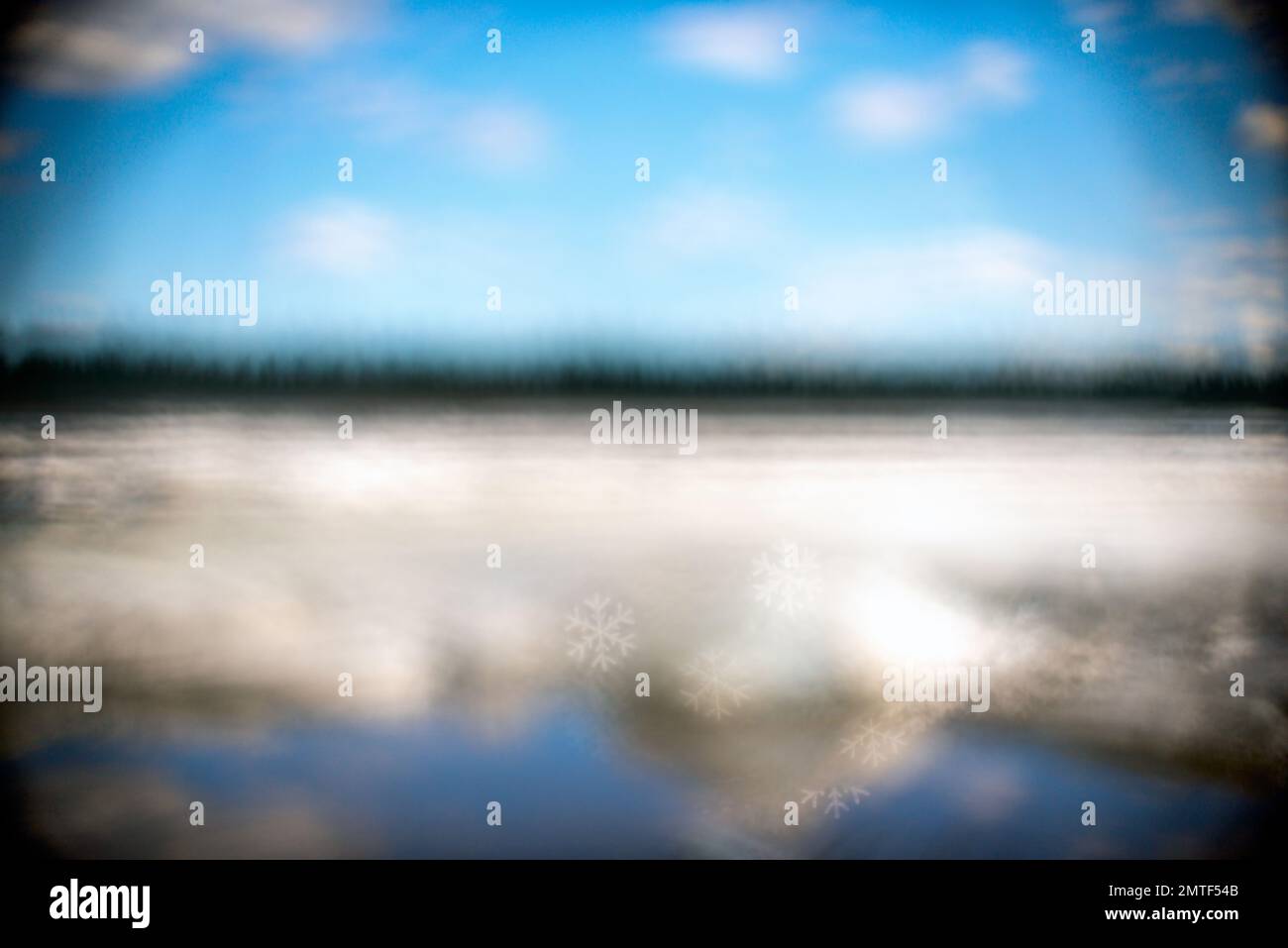 Abstract photo of a blurred river with a blue sky and white clouds with ...
