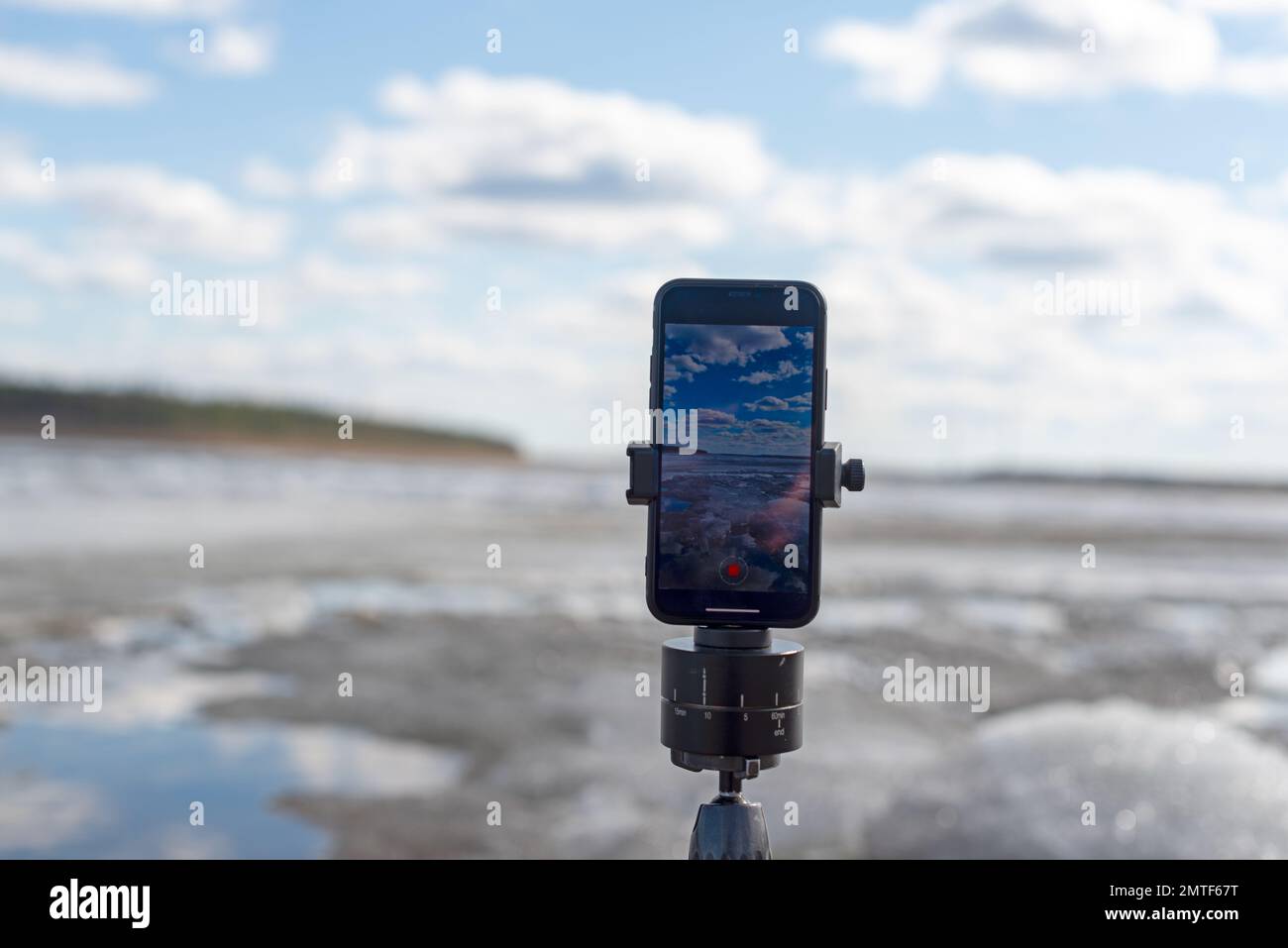 A mobile phone shoots a video of the spring ice drift during the day on ...