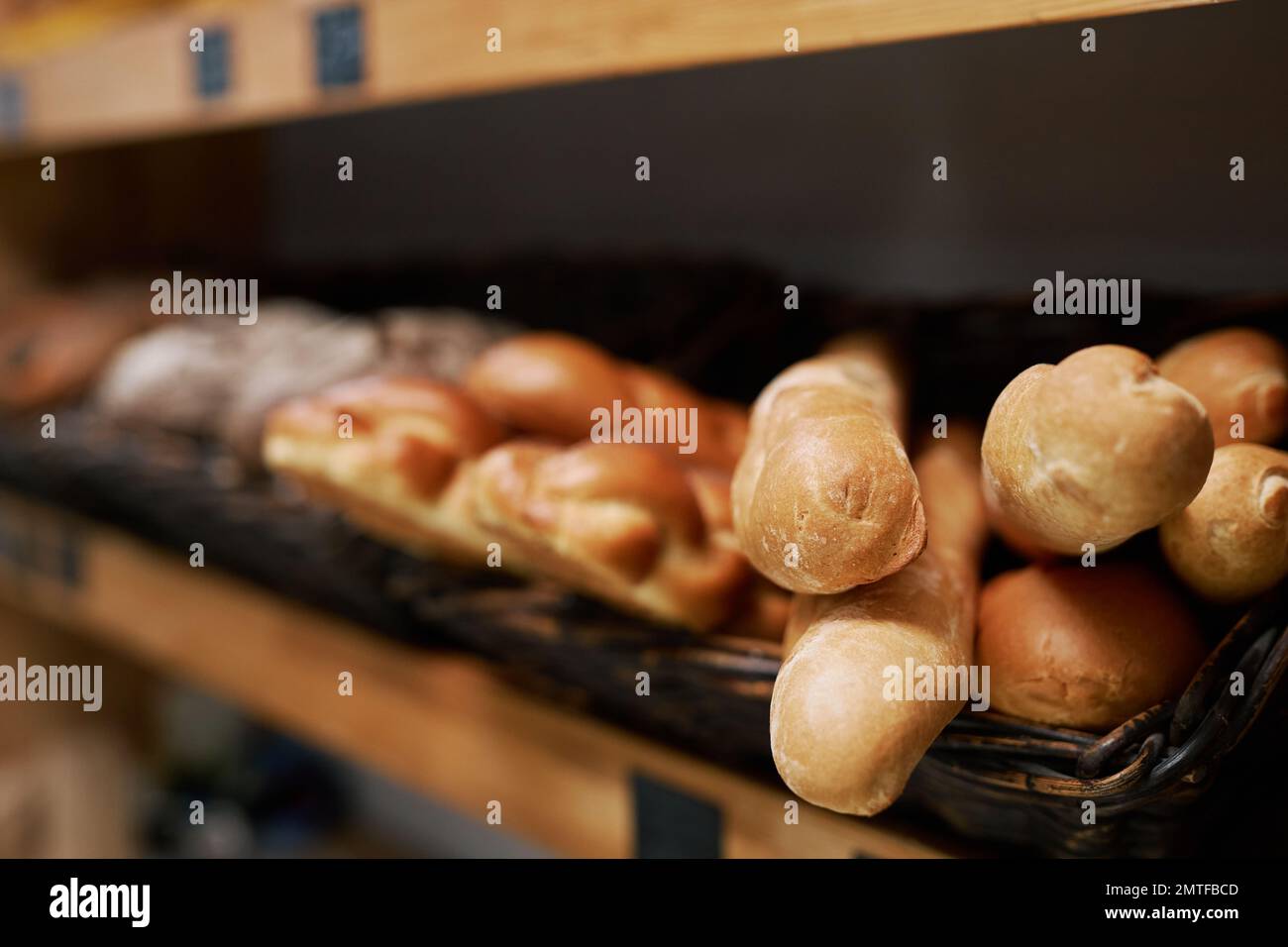 Various types of freshly baked bread on shelves in bakery Stock Photo ...