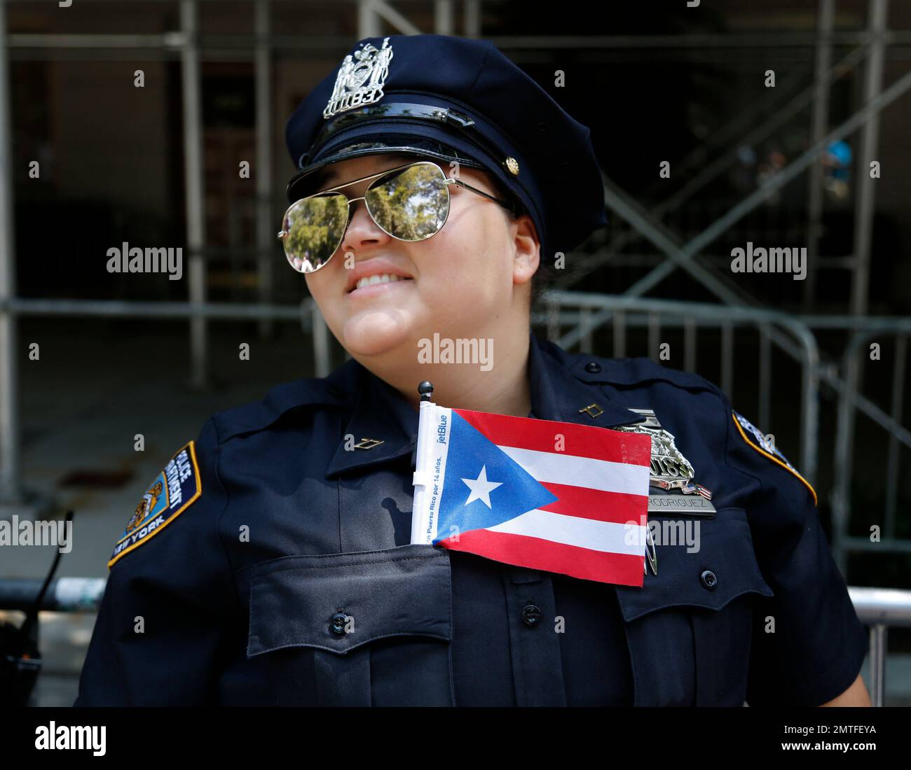 A police officer wears a Puerto Rican flag while working during the ...