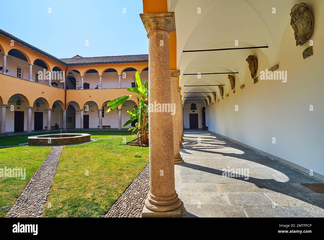 The medieval shady arcade with rib-vaulted ceiling and stone pillars in ...