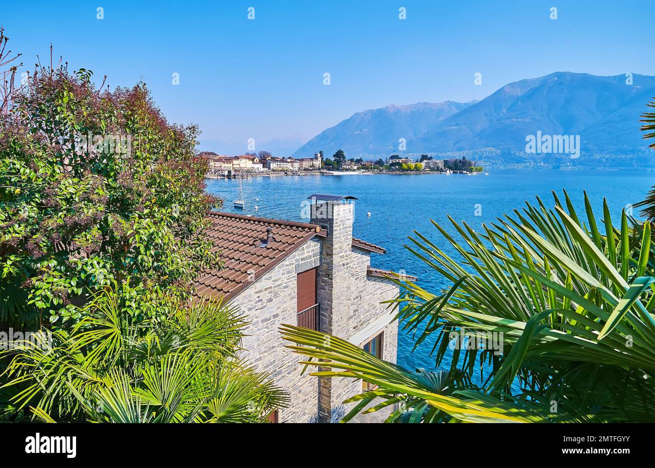The lakeside garden and stone villa with Lake Maggiore and hazy Alps in ...