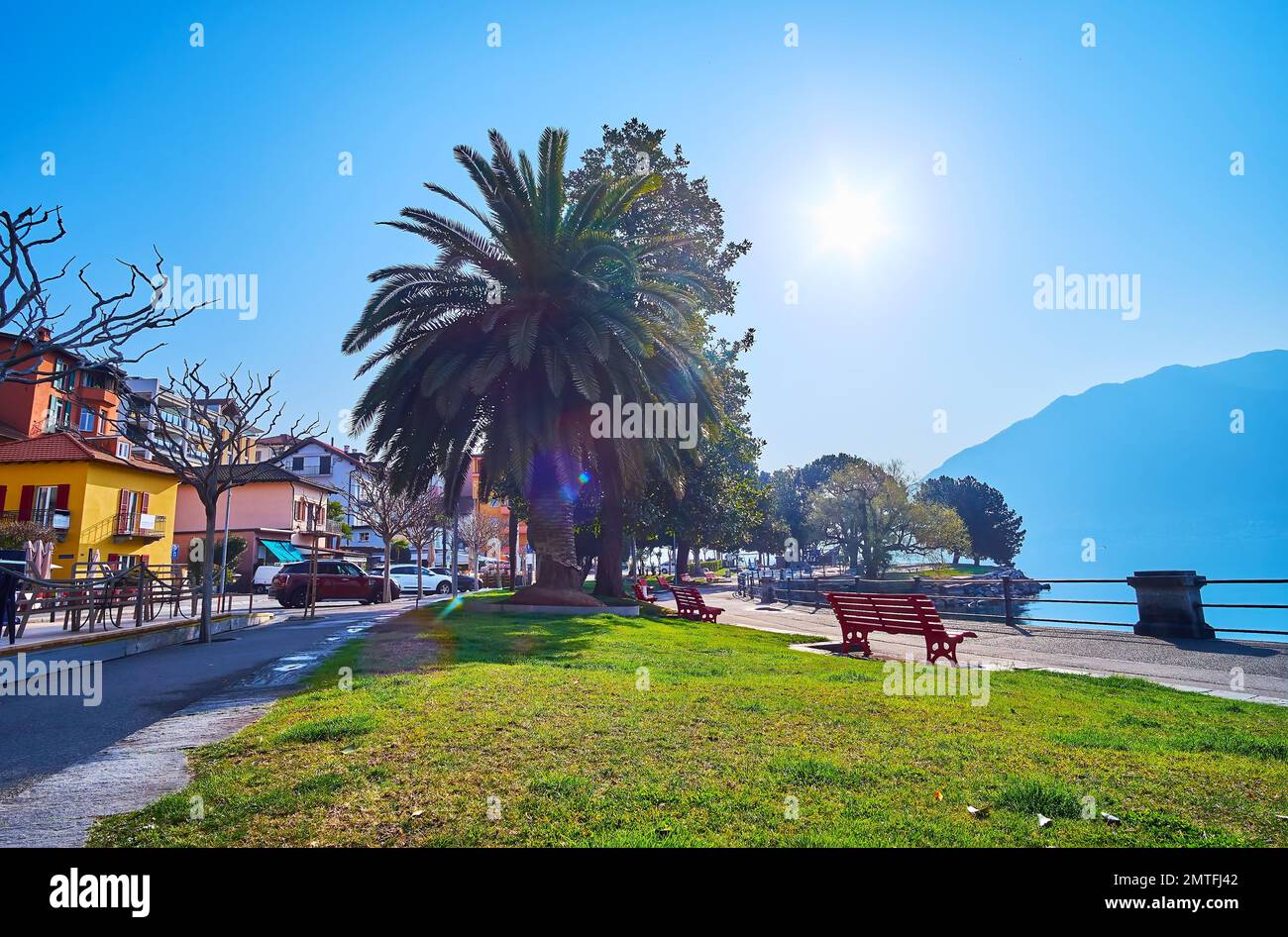 Bright morning sun over the spread park on embankment of Lake Maggiore ...