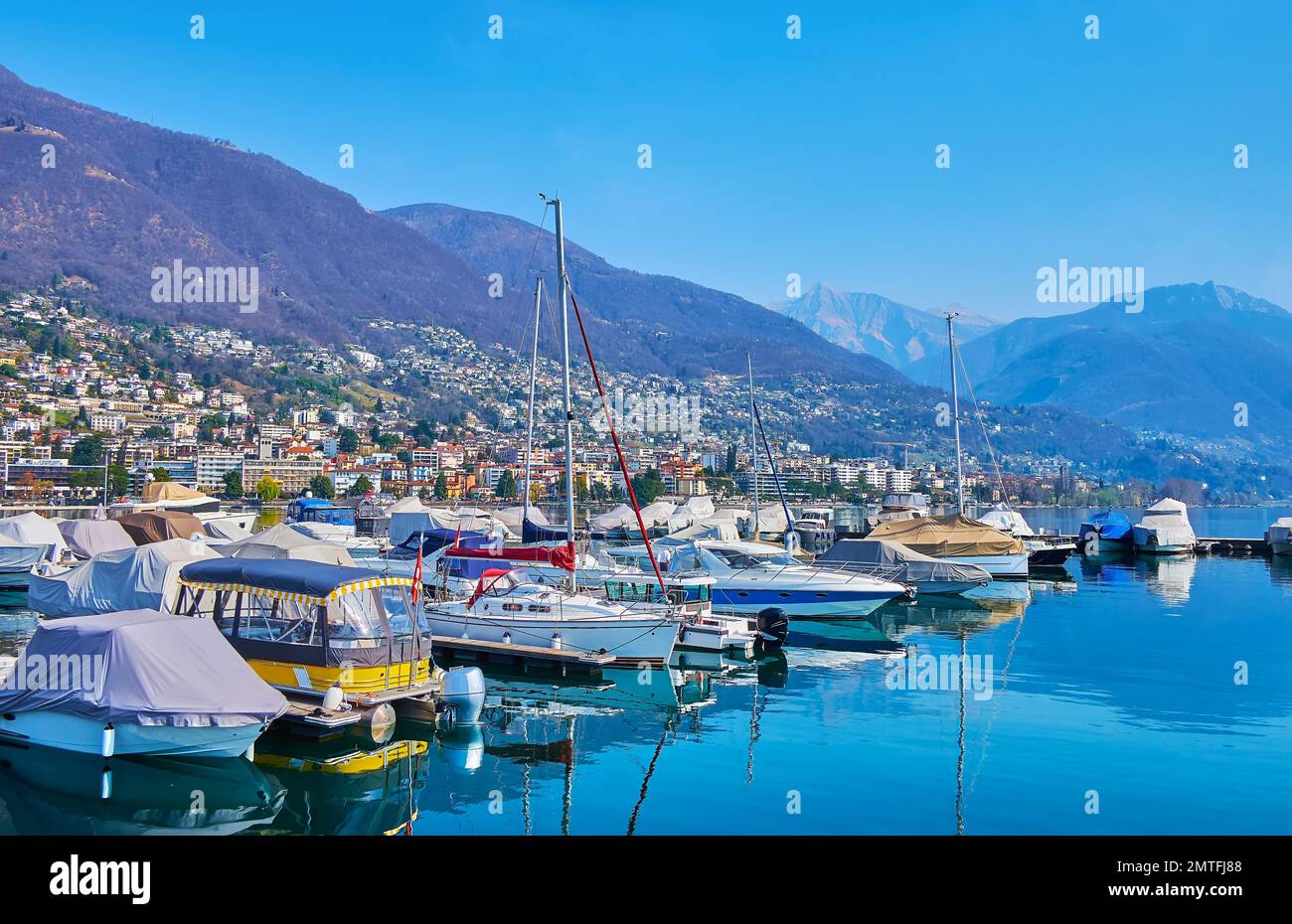 The line of moored boats and yachts on Lake Maggiore with Alpine slopes ...