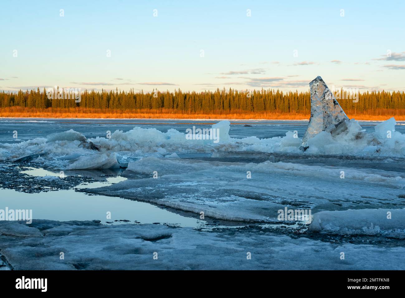 An ice floe in the form of a shark's fin with a reflection of clouds ...