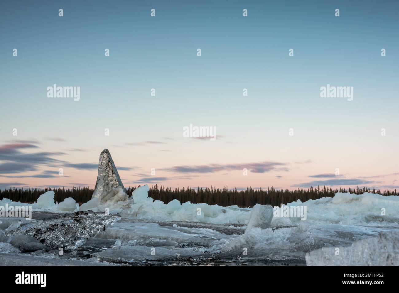 An ice floe in the form of a shark's fin with a reflection sticks out ...
