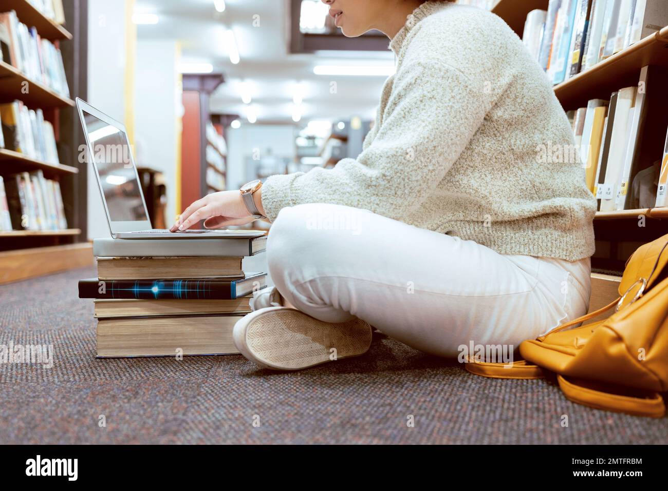 Books, laptop or student typing on library floor for research ...