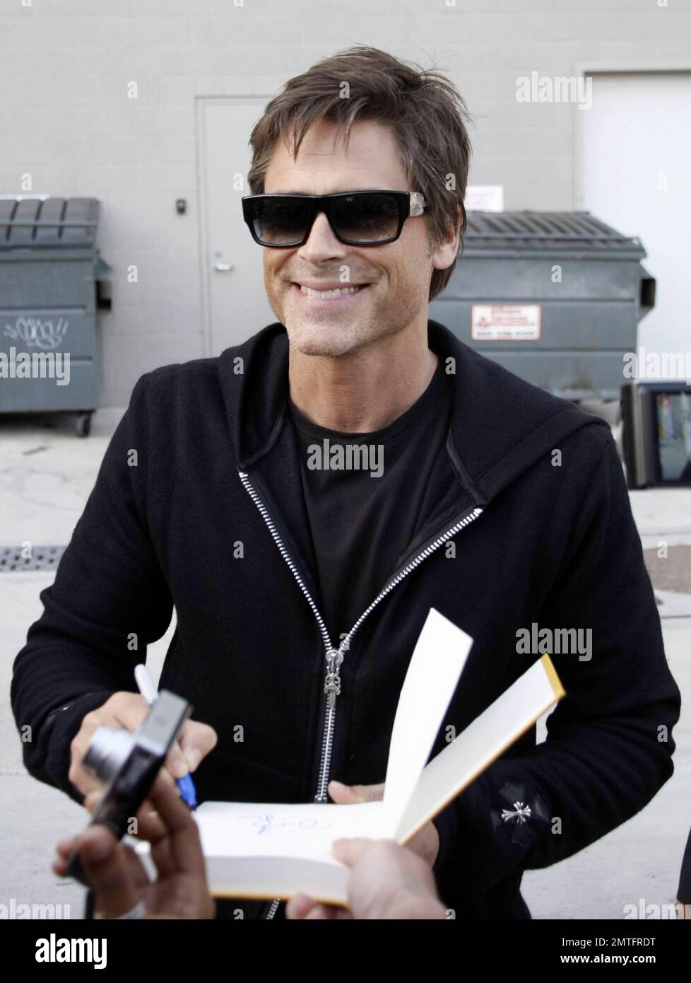 Rob Lowe signs autographs as he arrives at the "Jimmy Kimmel Live ...