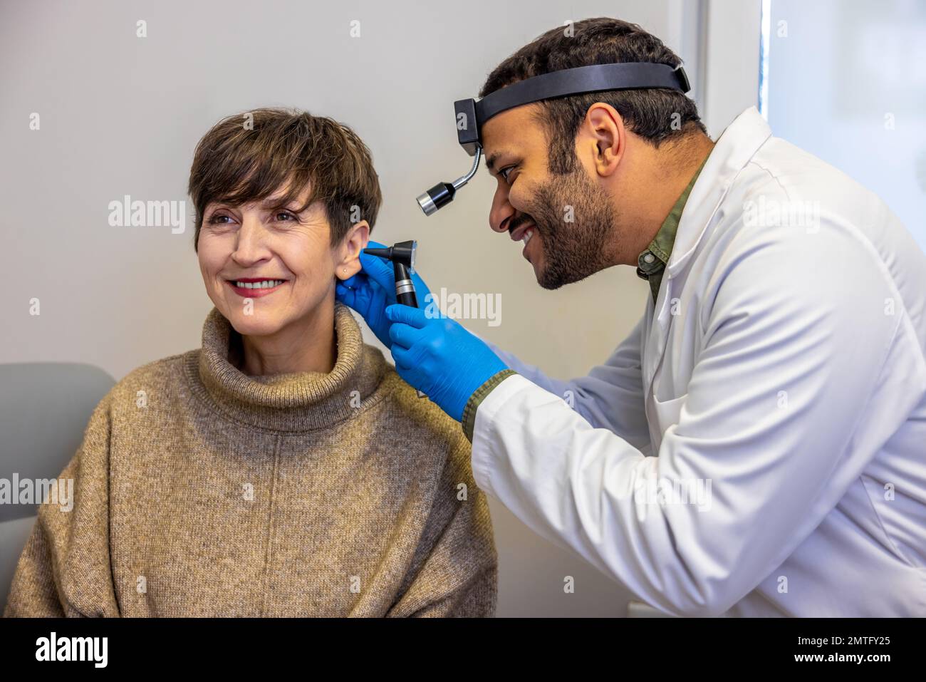 ENT doctor examinine patients ear with endoscope Stock Photo - Alamy
