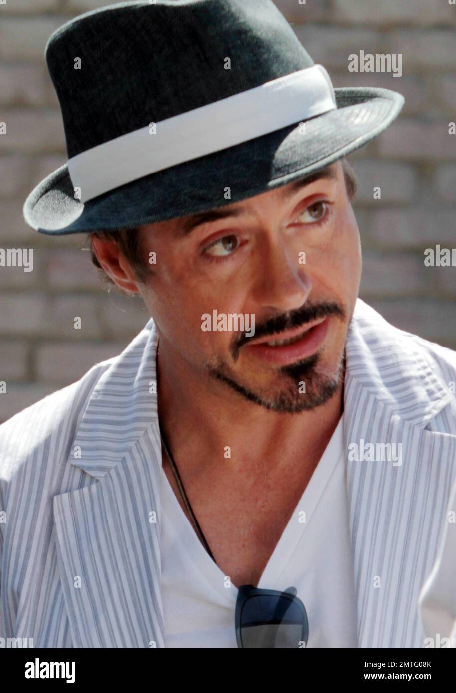 Wearing a black fedora and striped jacket with white pants and a t ...