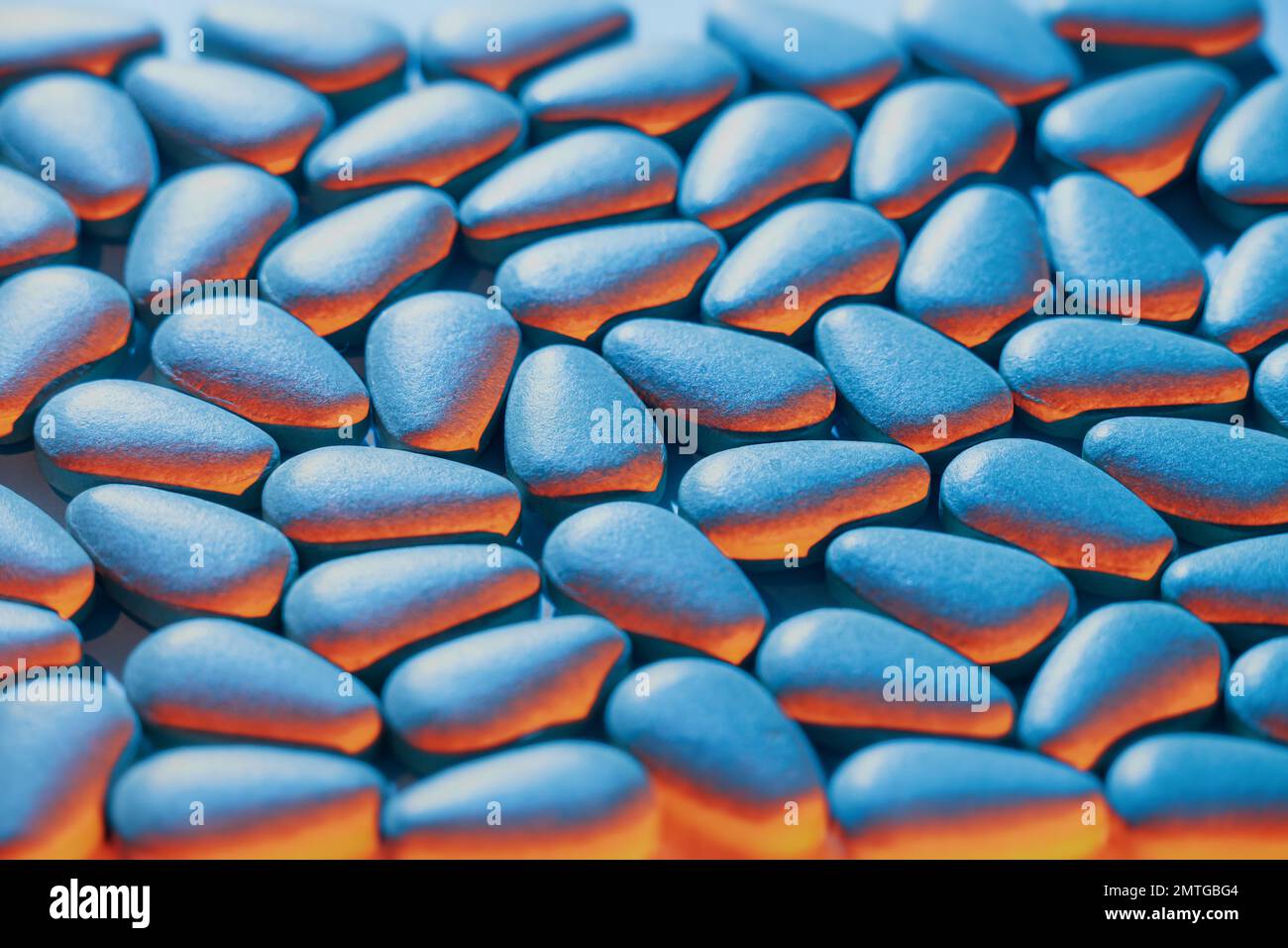 Shining oval pill blue orange pills on a flat surface - orange shining ...