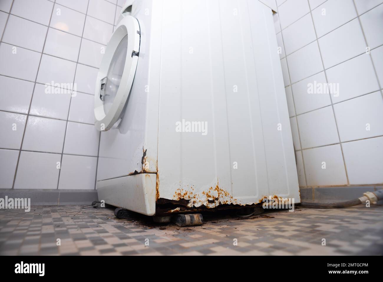 Rusty old washing machine in a bathroom - broken corner - wide angle ...