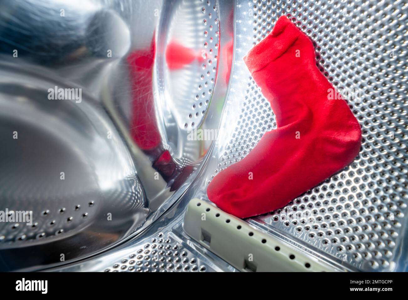 Red sock in a washing machine drum - wide angle Stock Photo - Alamy