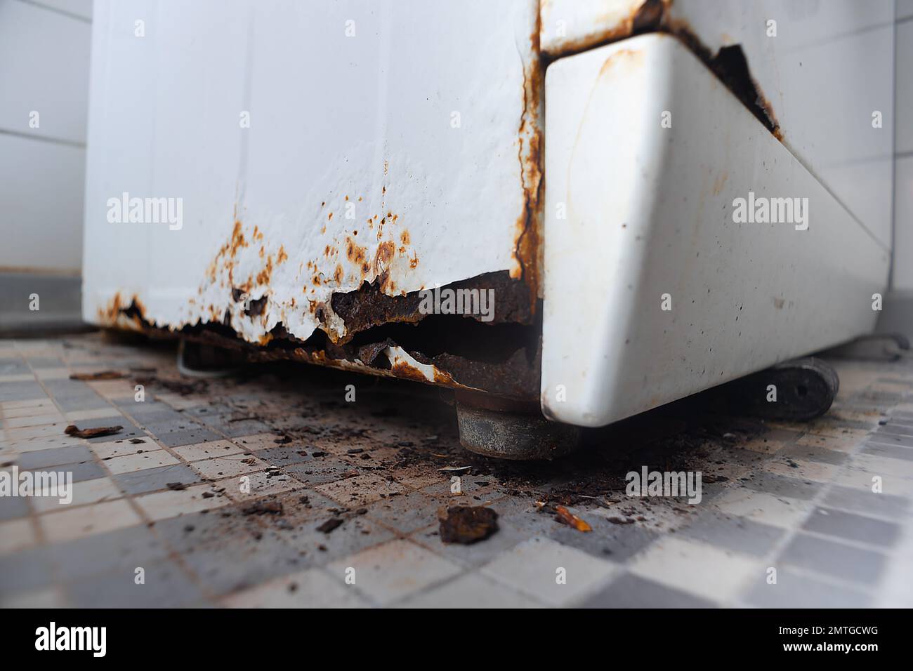 Rusty old washing machine in a bathroom - broken corner - wide angle ...