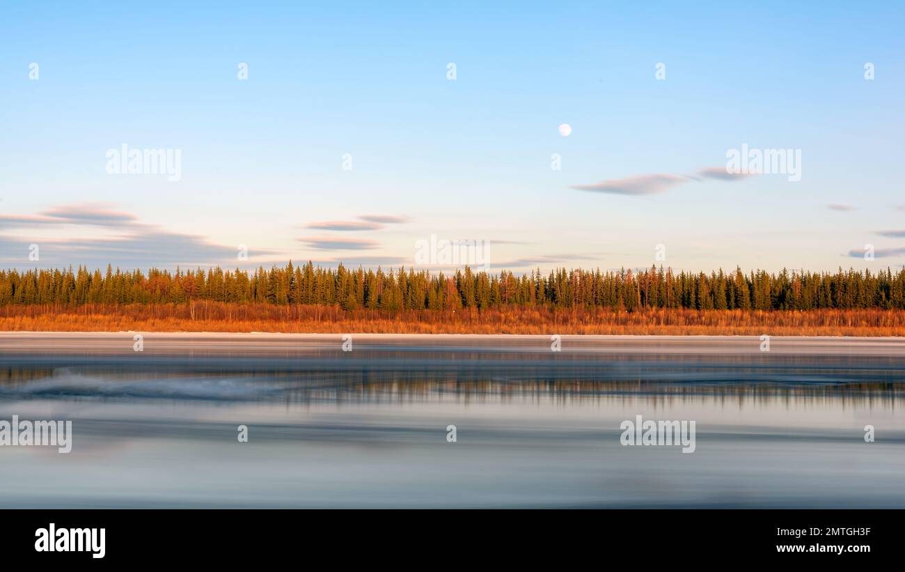 An ice floe floats on the Vilyui River in Yakutia against the backdrop ...