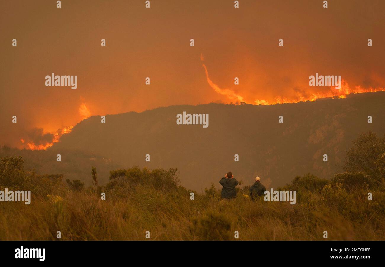In this photo taken Wednesday, June 7, 2017, onlookers watch a blaze in ...
