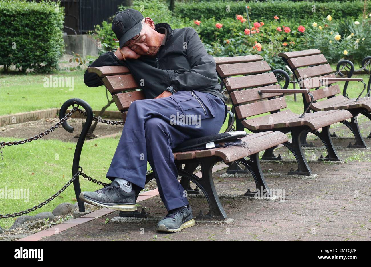 A man takes a nap on a bench in the Hibiya park in Tokyo, Thursday ...