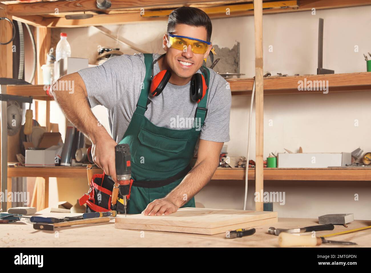 Professional carpenter twisting screw with drill at workbench Stock ...