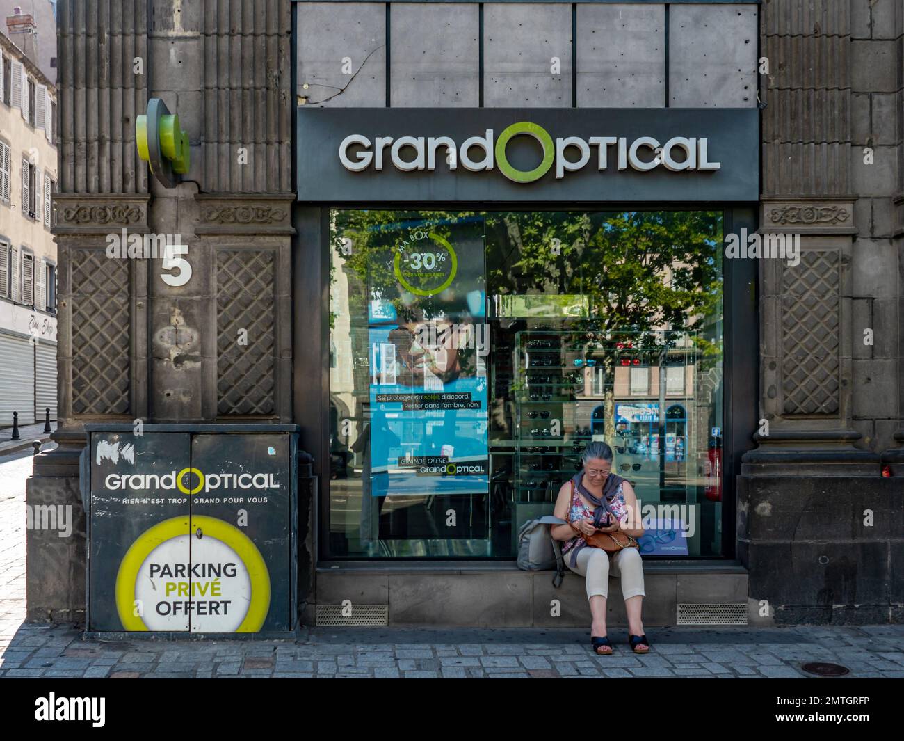 The entrance of the Grand Optical store with the logo of the company on ...