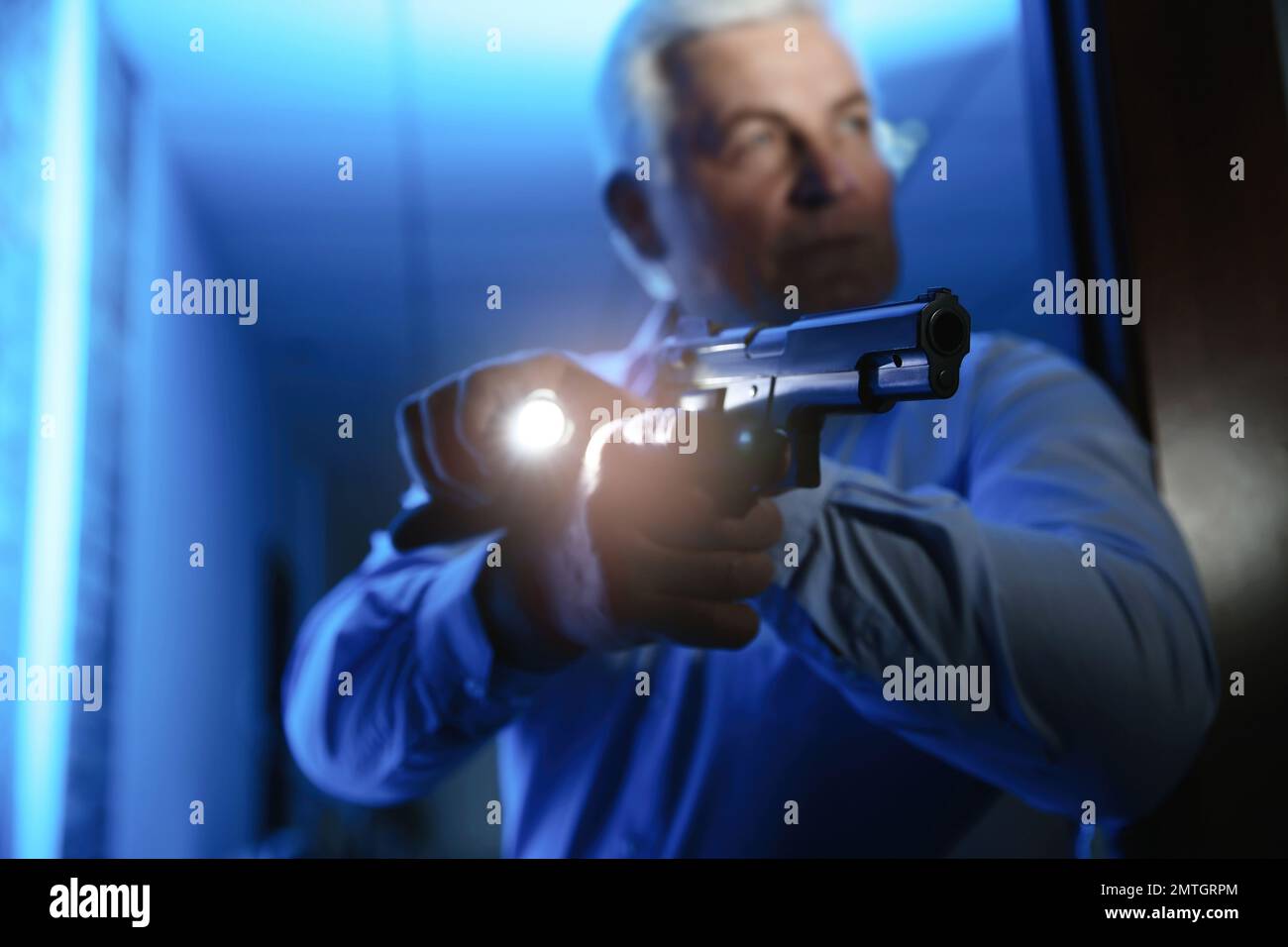 Professional security guard with gun checking dark room, focus on hand ...