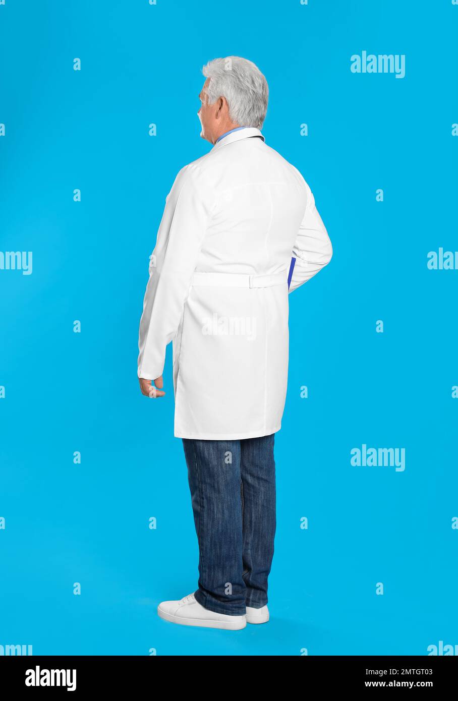 Senior doctor on light blue background, back view Stock Photo - Alamy