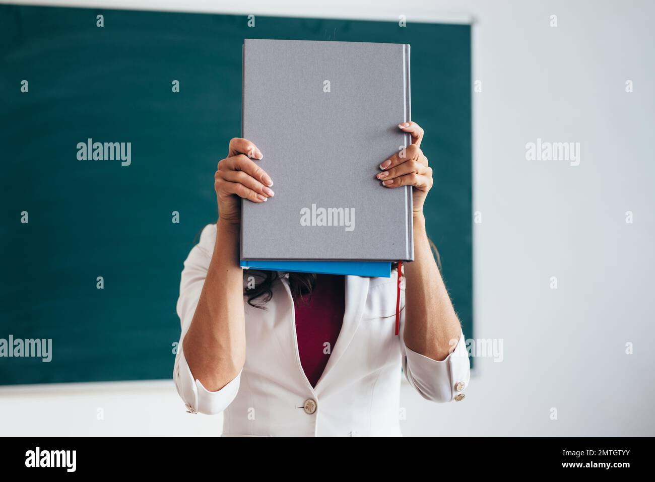 Girl standing behind blackboard hi-res stock photography and images - Alamy