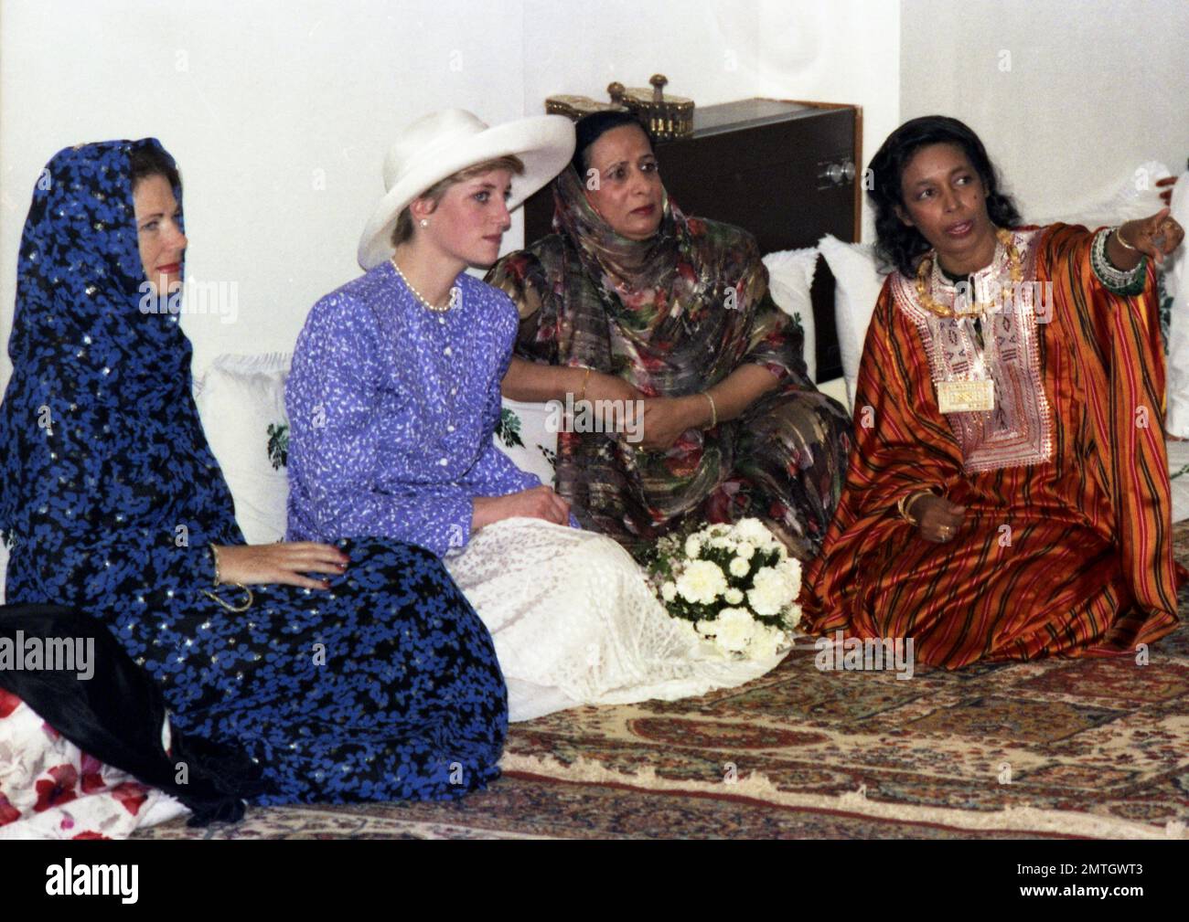 Princess Diana, the Princess of Wales, sits on the floor with local ...