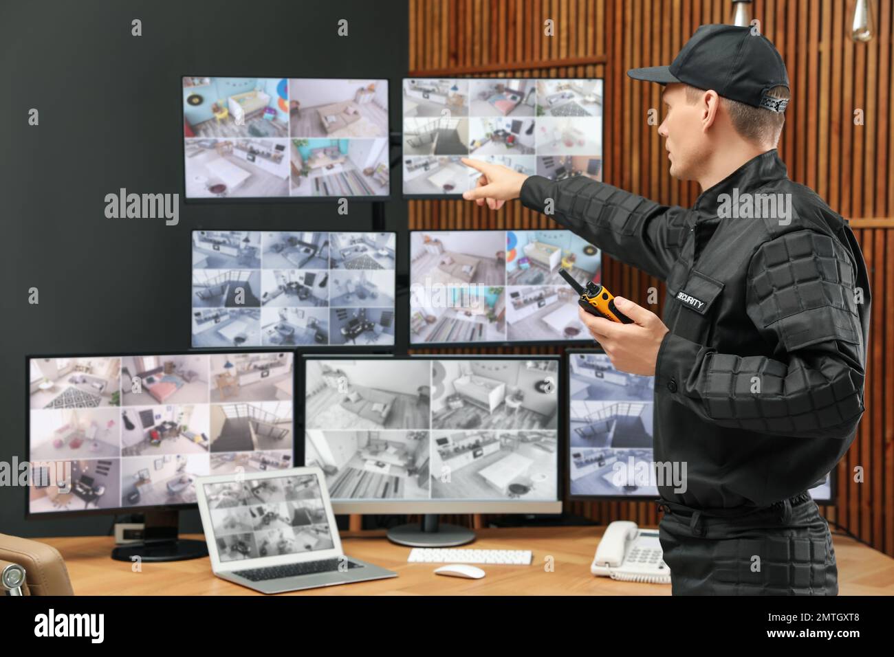 Security guard with portable transmitter monitoring modern CCTV cameras ...