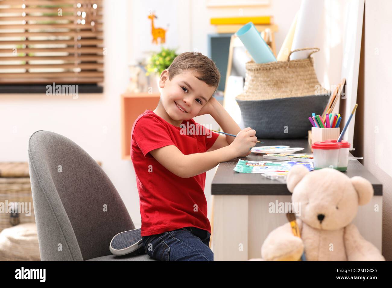 Little child painting at table in room Stock Photo - Alamy