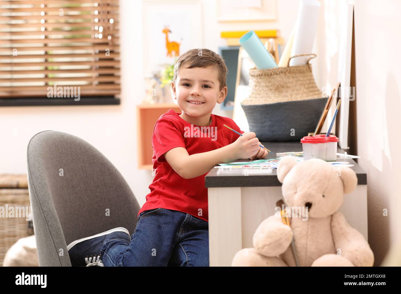 Little child painting at table in room Stock Photo - Alamy