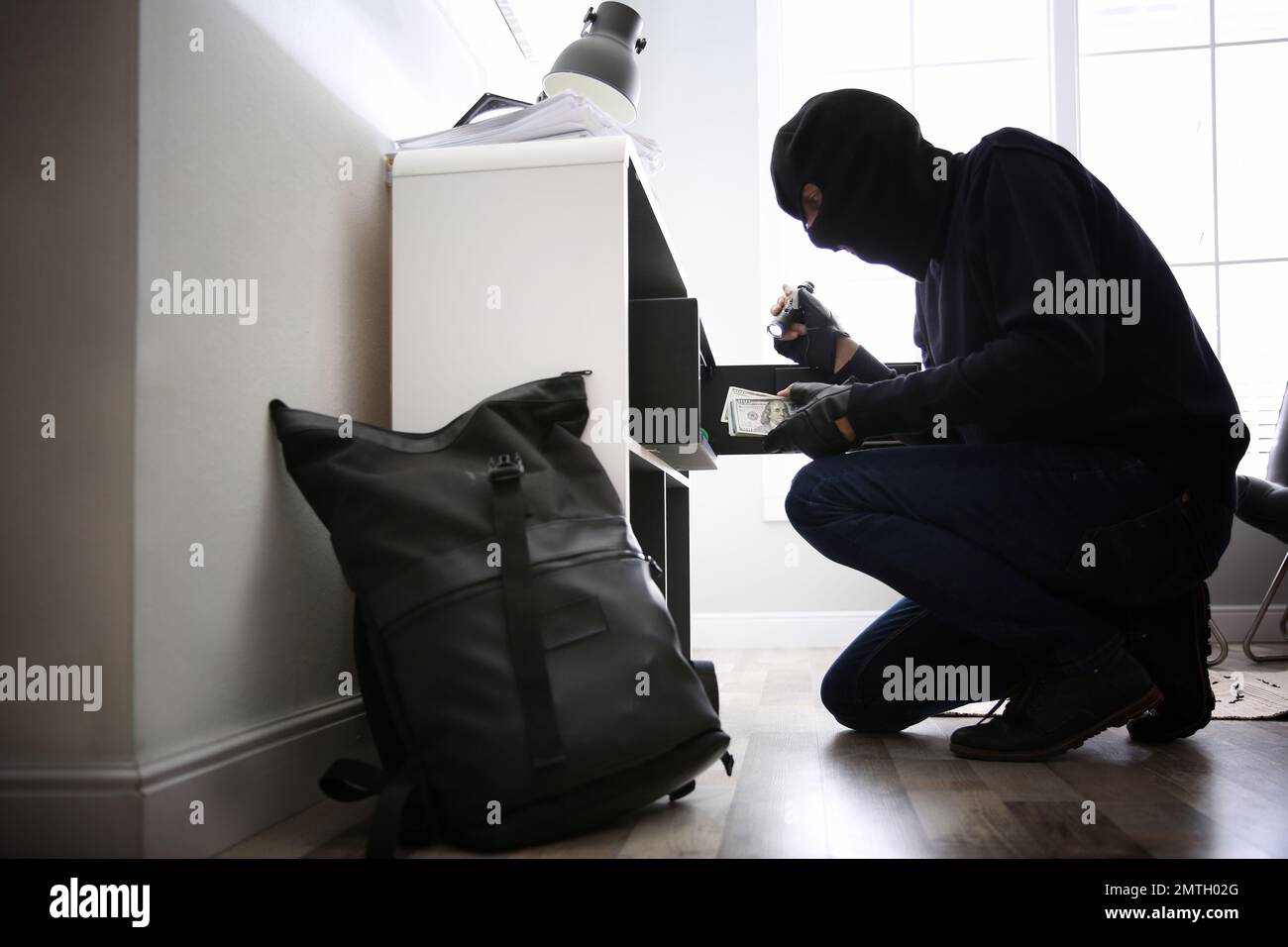 Thief taking money out of steel safe indoors Stock Photo - Alamy