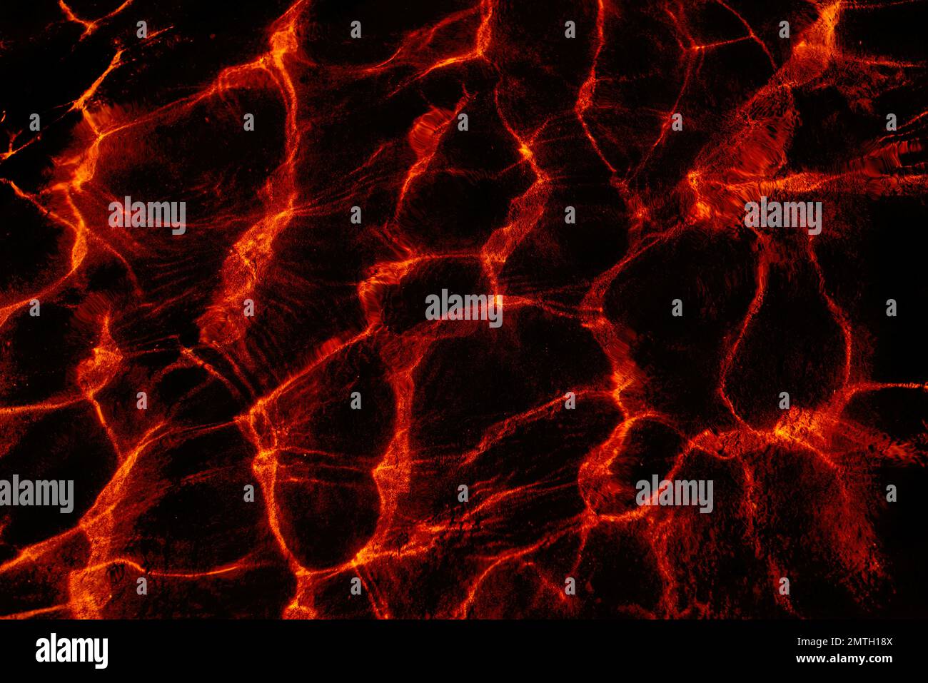 Abstract surface textures with a black background and a bright red glow ...